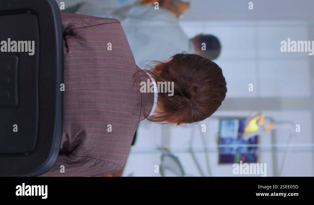 Back view of patient filling in dental form sitting on chiar Stock ...