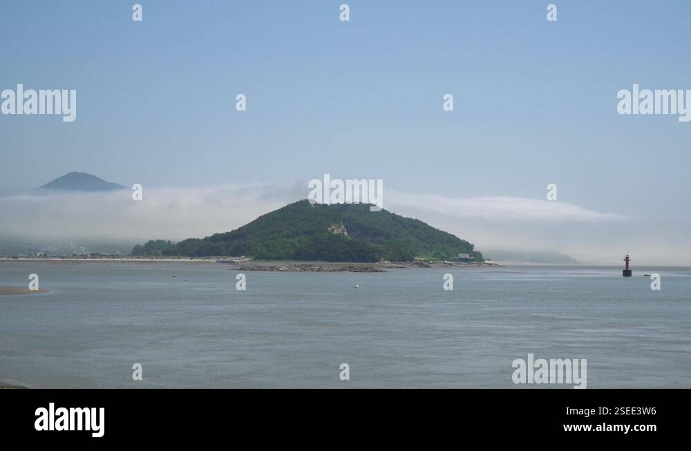 Red navigational buoy floating in Yellow sea between islands, mountains ...
