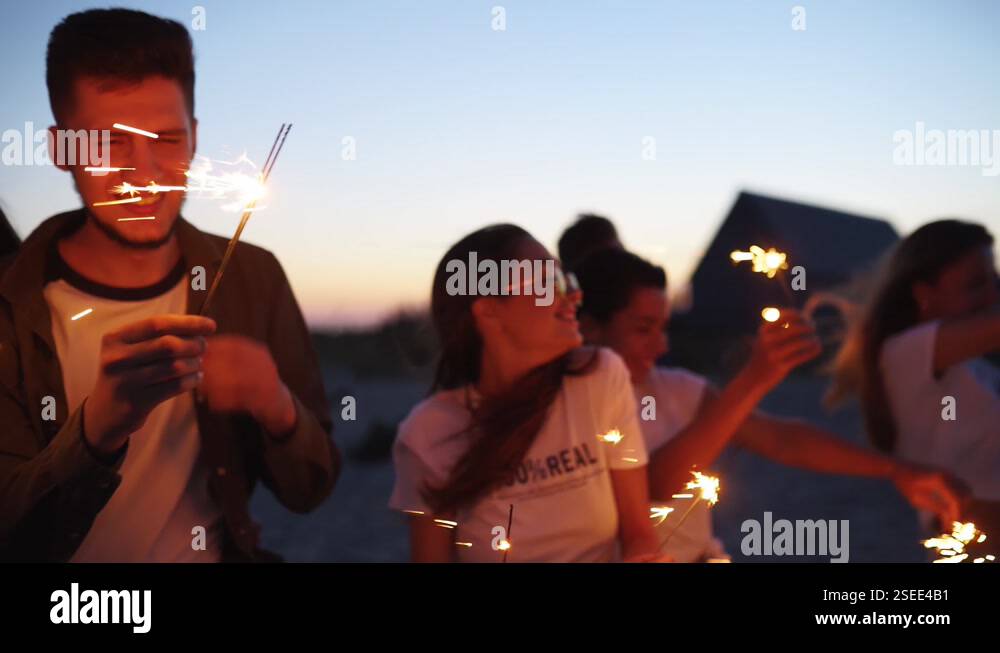 Friends walking, dancing, having fun at night party at the seaside with ...