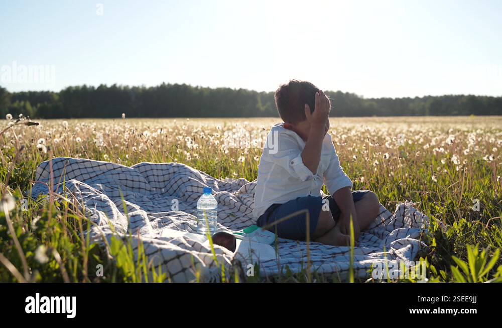 A dreamy boy. The child reflects. A boy sits in a field. Thoughts about ...