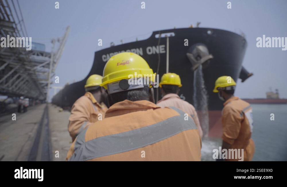 Dockworkers In Safety Hard Hats Pulling Together Mooring Line Of A Big ...