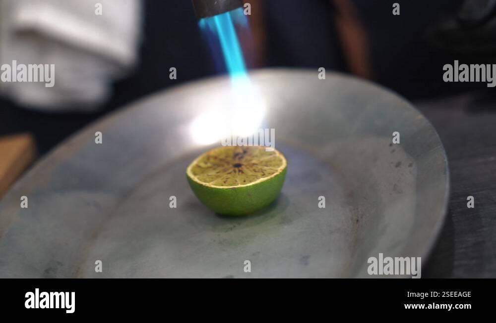 gas burner hand held used to torch a cut lime on a metal dish Stock ...