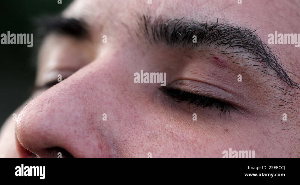Young man close-up eyes in contemplation and meditation having faith ...
