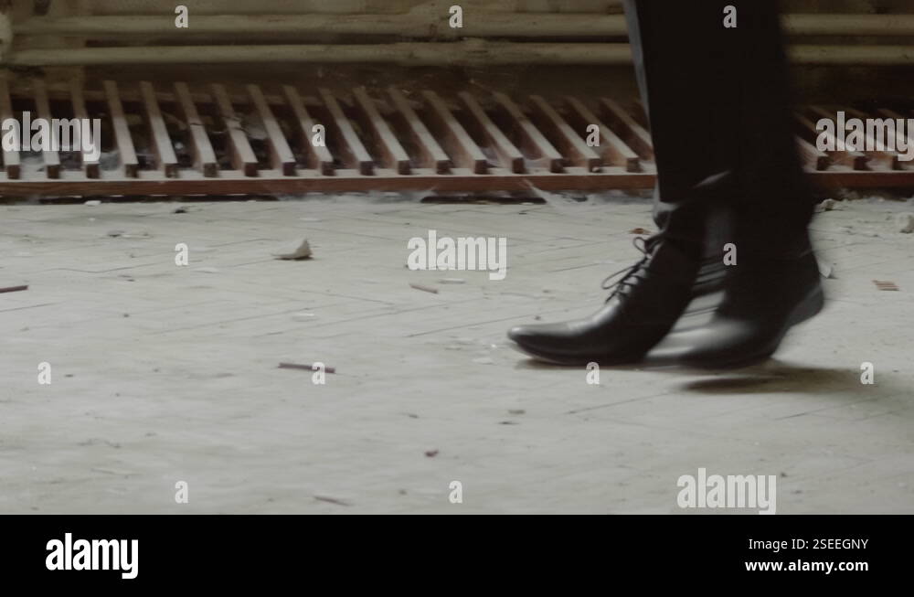 Adult in boots walks stealthily inside parking garage, crime scene, low ...