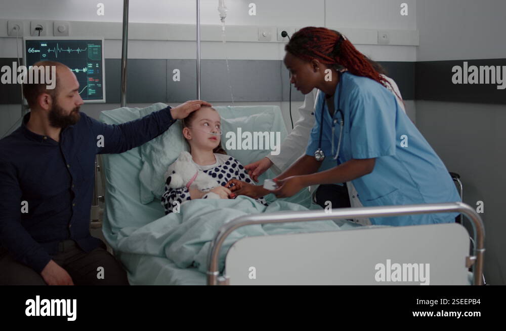 Sick patient resting in bed wearing oxygen nasal tube discussing with ...