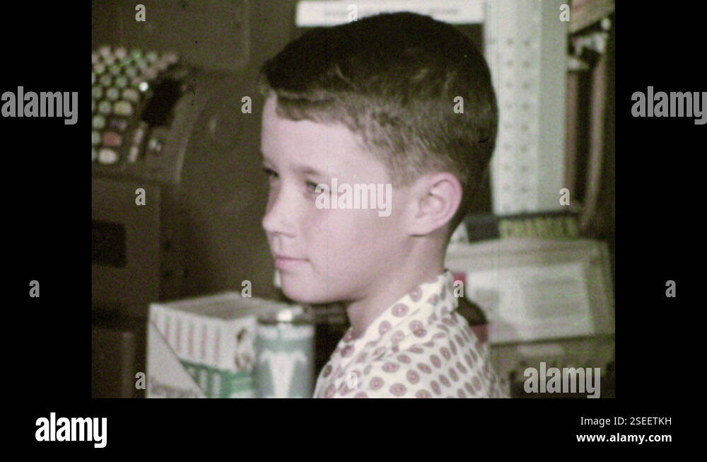 1960s: Hands lift coffee maker from window display. Boy watches worker ...