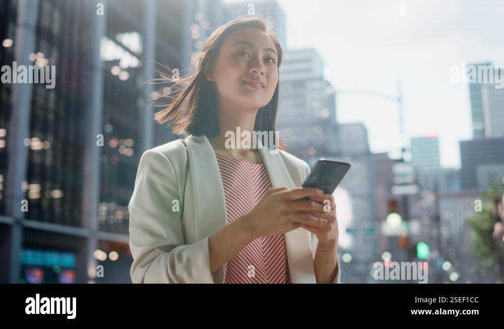 Japanese Female Uses Smartphone on City Street Stock Video Footage - Alamy