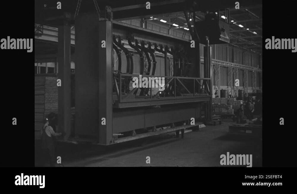 1940s: An overhead crane skillfully maneuvers a hydraulic press, while ...