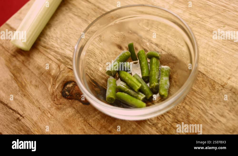 Woman's hands cutting piattoni frozen green beans close up. 4k ...