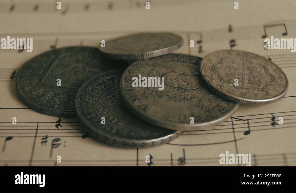 Silver antique coins lie on the sheet of music close up, financial ...