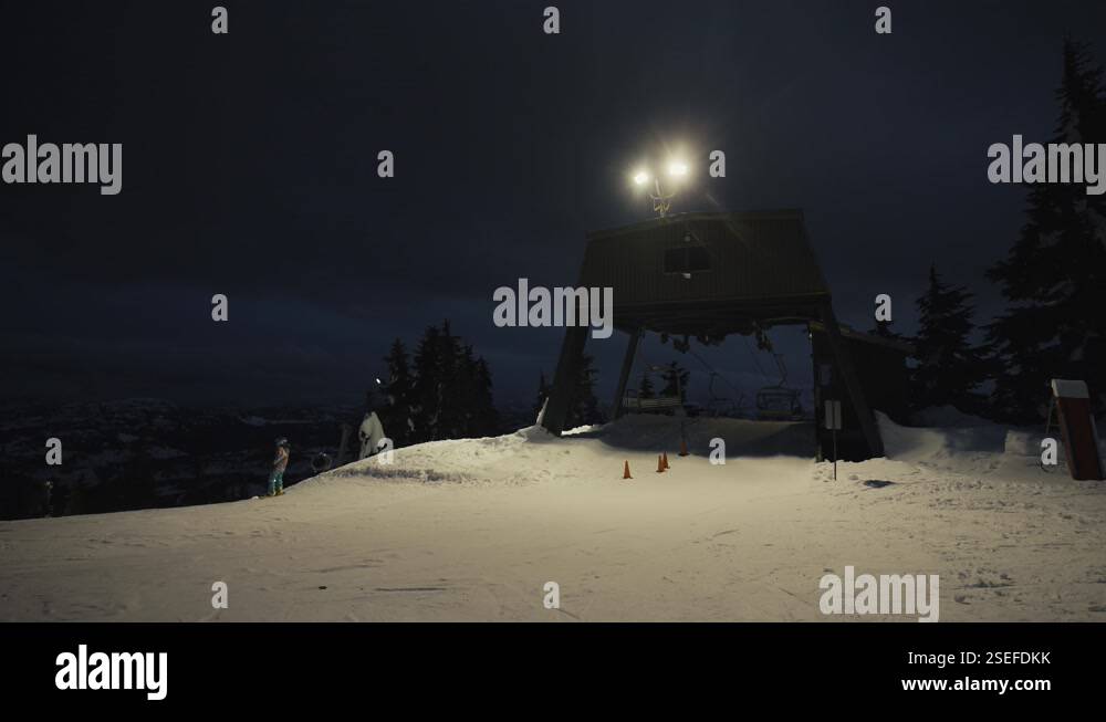 4k Top of ski lift at night, turning and offloading skiiers Shot on ...