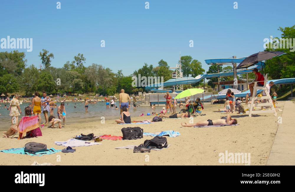 People Enjoying In Crowded Swimming Area With Gigantic Water Slides In ...