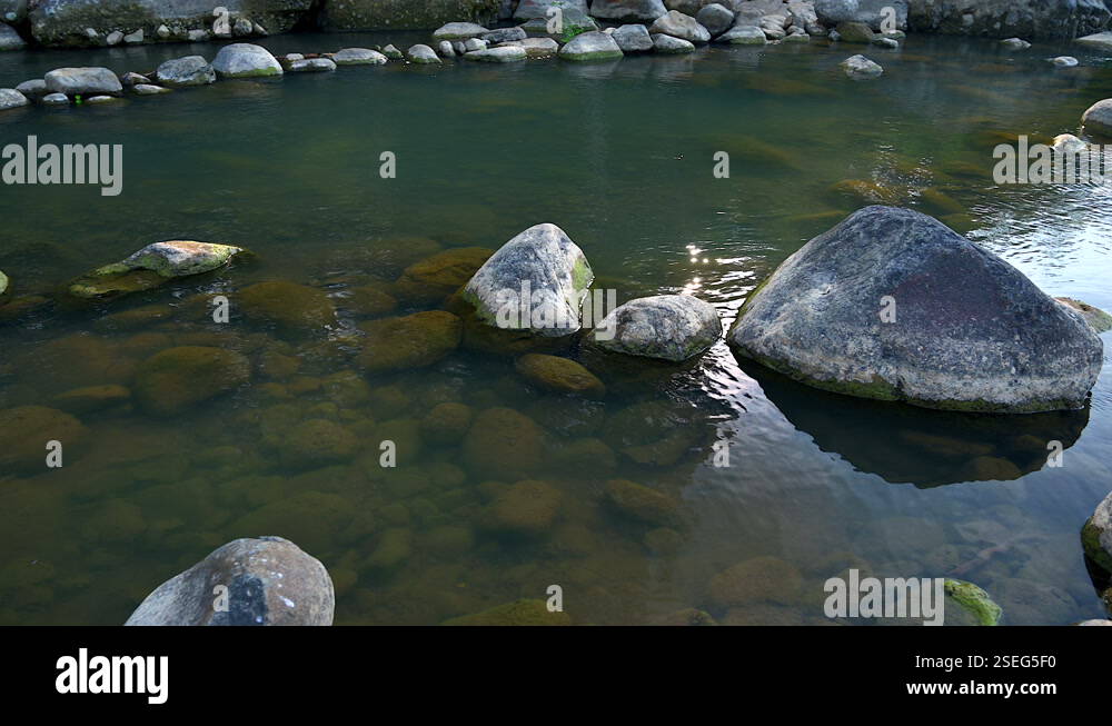 Peaceful riverside with fresh water flow between rocks boulder panning ...
