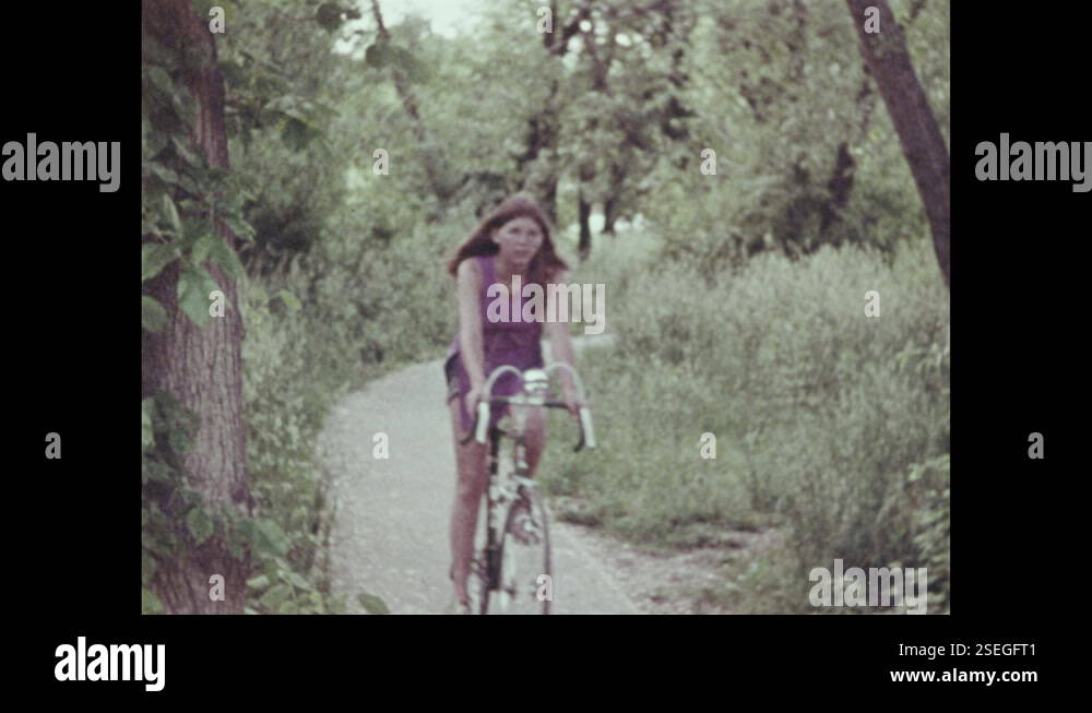 1970s: People bike along path. People sit at picnic tables. Woman walks ...