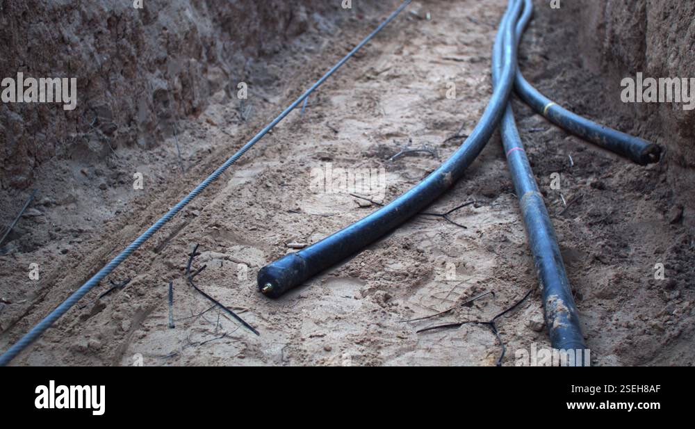 Footage of the trenches with pipes and cable being dragged ...