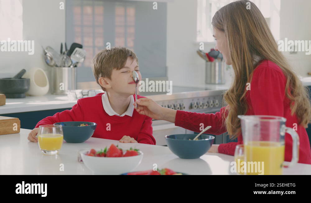 Brother And Sister Wearing School Uniform In Kitchen Have Fun Hanging ...