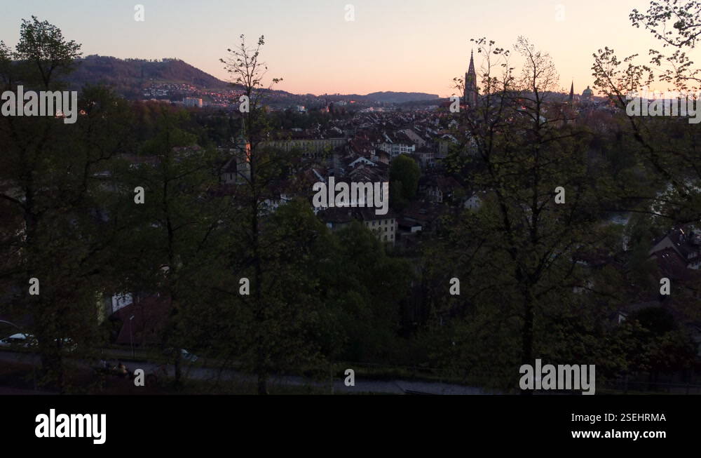 Drone pass through trees and fly above the city of Berne in Switzerland ...