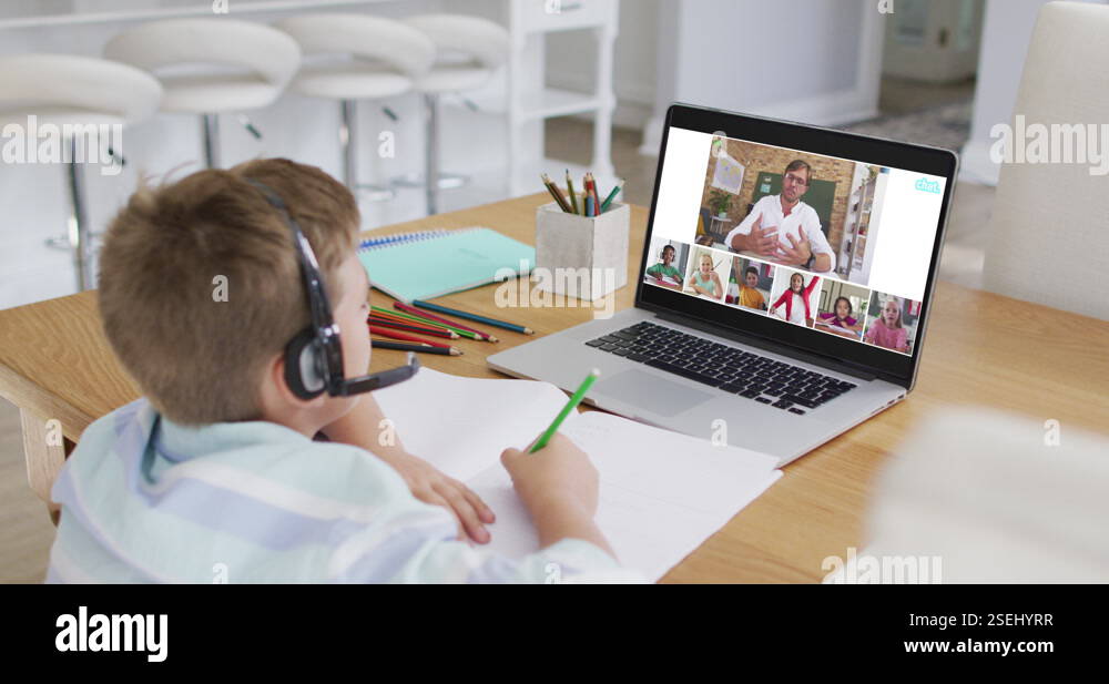 Schoolboy using laptop for online lesson at home, with diverse teacher ...