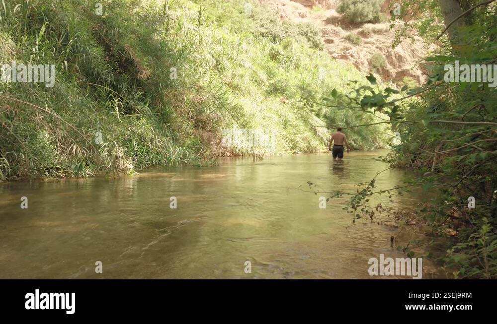 Man Walking On Shallow Water River Of Ayna Forest In Spain. - Sideways ...