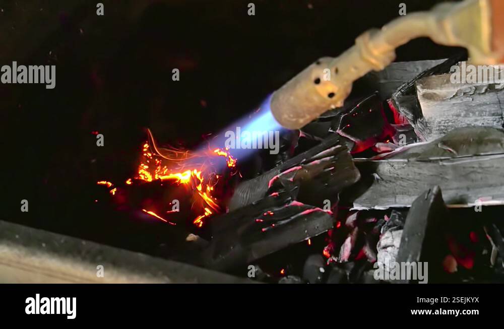 high flame of burning butane heating the coal. Charcoal burning on with ...