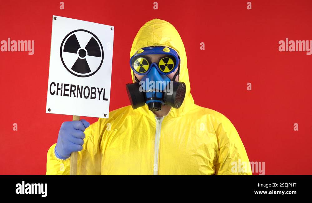 A man in a protective chemical suit, a mask and a banner in his hands ...