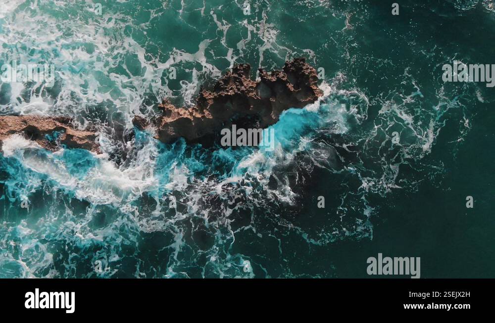 Top Down View Of Foamy Ocean Waves Splashing On Rocks At Capitolo Beach ...