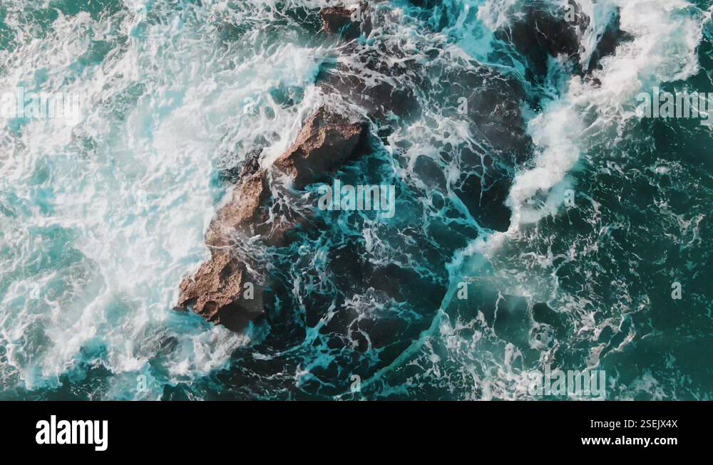 Topdown Of Ocean Waves Splash Against Rocks At Capitolo Beach In ...