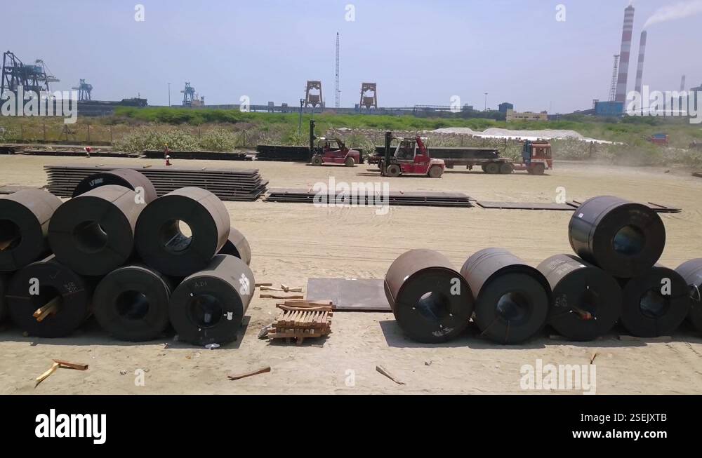 Aerial view of metal coils and forklifts, outdoors at a terminal marina ...