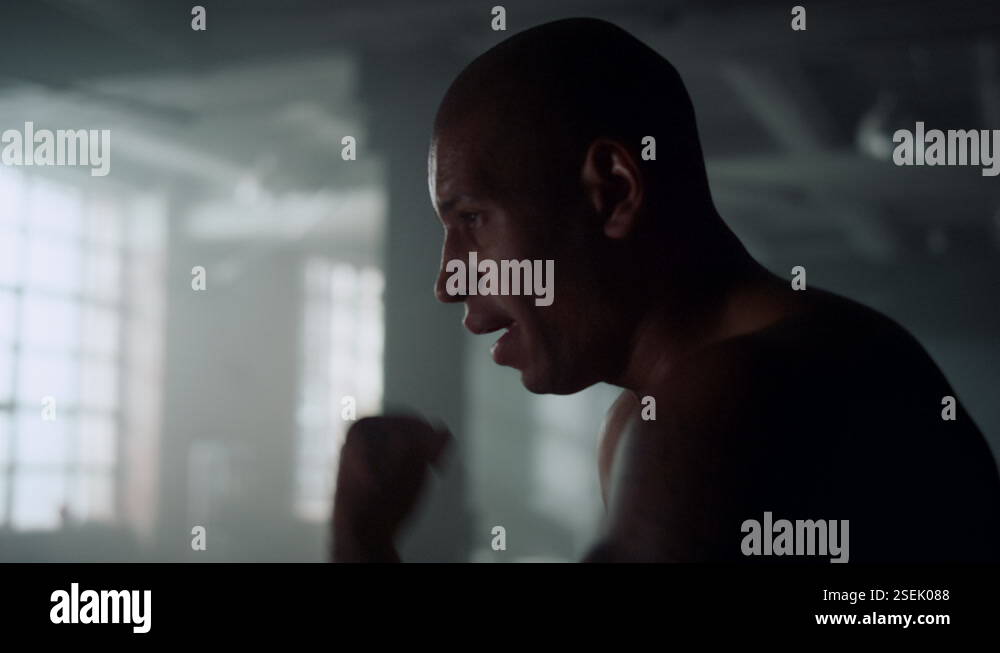 Sportsman practicing kicks during box workout. Boxer punching air with ...
