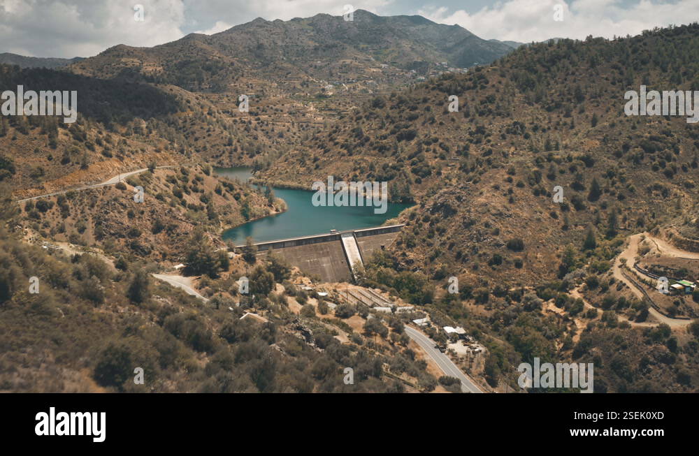 Aerial view water reservoir in mountains. Dam blocks river in yellow ...