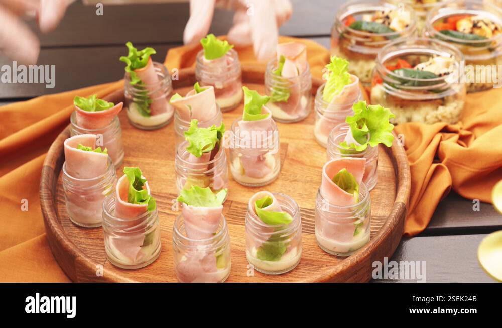 catering work. cups with meat snack are placed on a round wooden ...