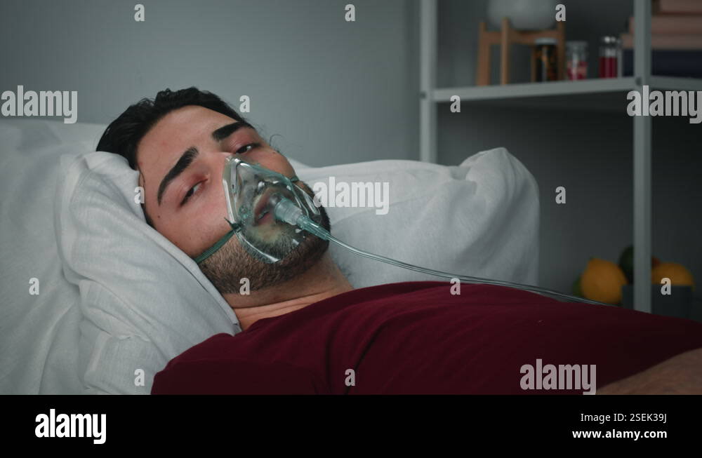Sick patient lying with oxygen mask in hospital ward, serious bad human ...