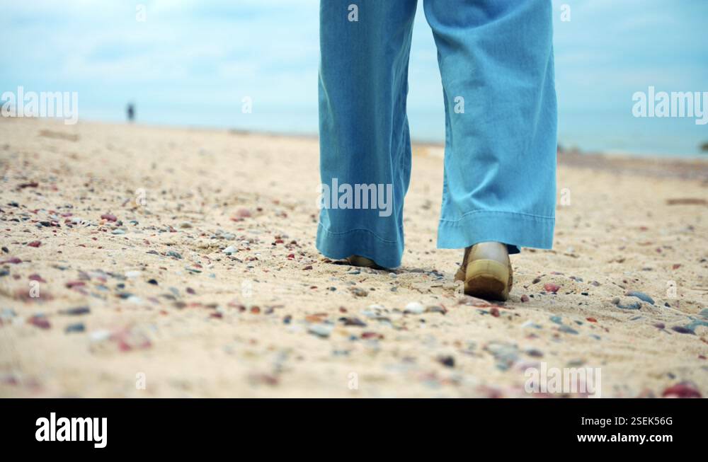 Female Wearing Blue Square Pants Walks On Stony Seaside Of Karkle Beach ...