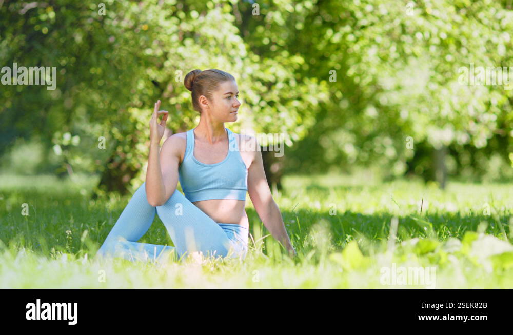 Lady in blue top and leggings sits in relaxation pose Stock Video ...