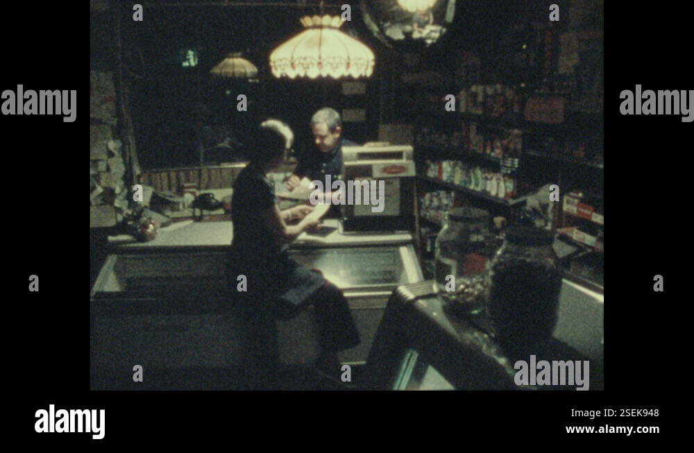 1970s: Man and woman in store after closing, stand on opposite sides of ...