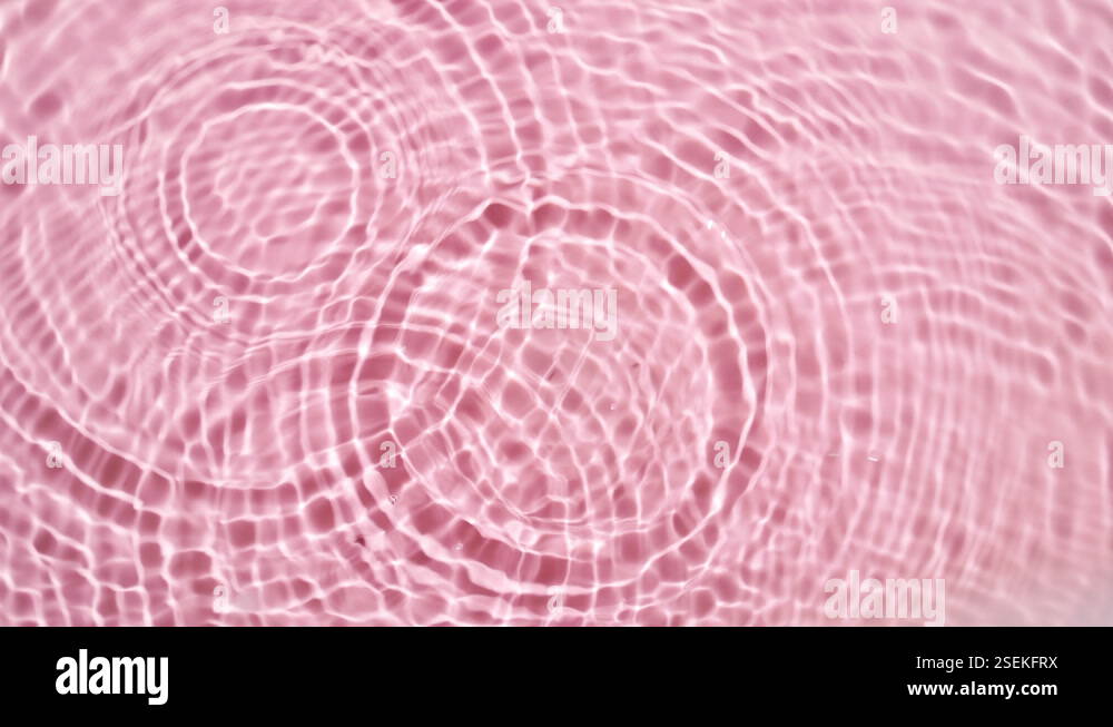 Drops falling in water making multiple water rings on pink bg Stock ...