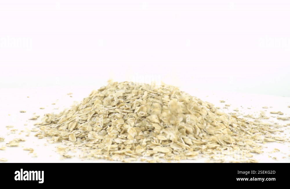 Oat flakes falling on heap of oat flakes rotating over white background ...