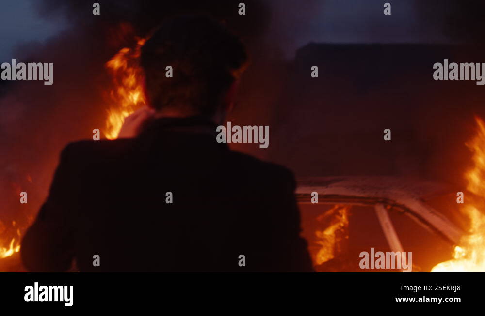 Man grabs his head, he is very upset because of the burned car in the ...