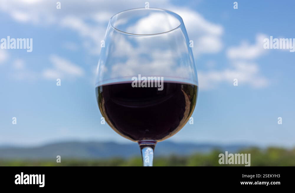 Glass of red wine against blue sky Stock Video Footage - Alamy