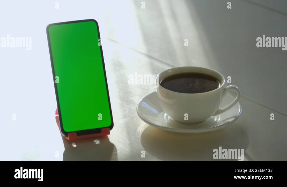 Mobile phone with blank green screen, front view, isolated on black ...