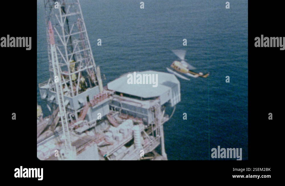 1970s: Helicopter hovers over a building on a ridge. Helicopter lands ...