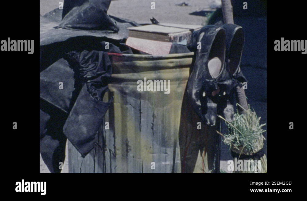 1970s: Boy and girl remove book from garbage can. Boy cleans book cover ...