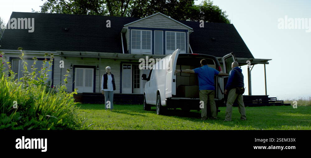 WIDE Two workers delivering package, bringing box from van to a house ...