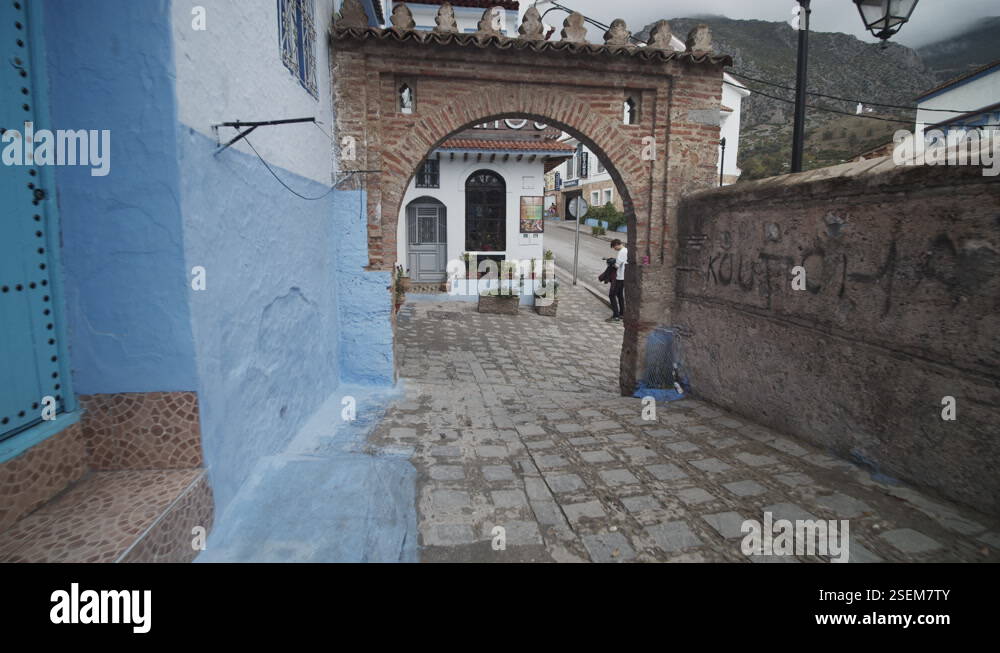 Walking under Bab El Hammar historic brick gate in blue city of ...