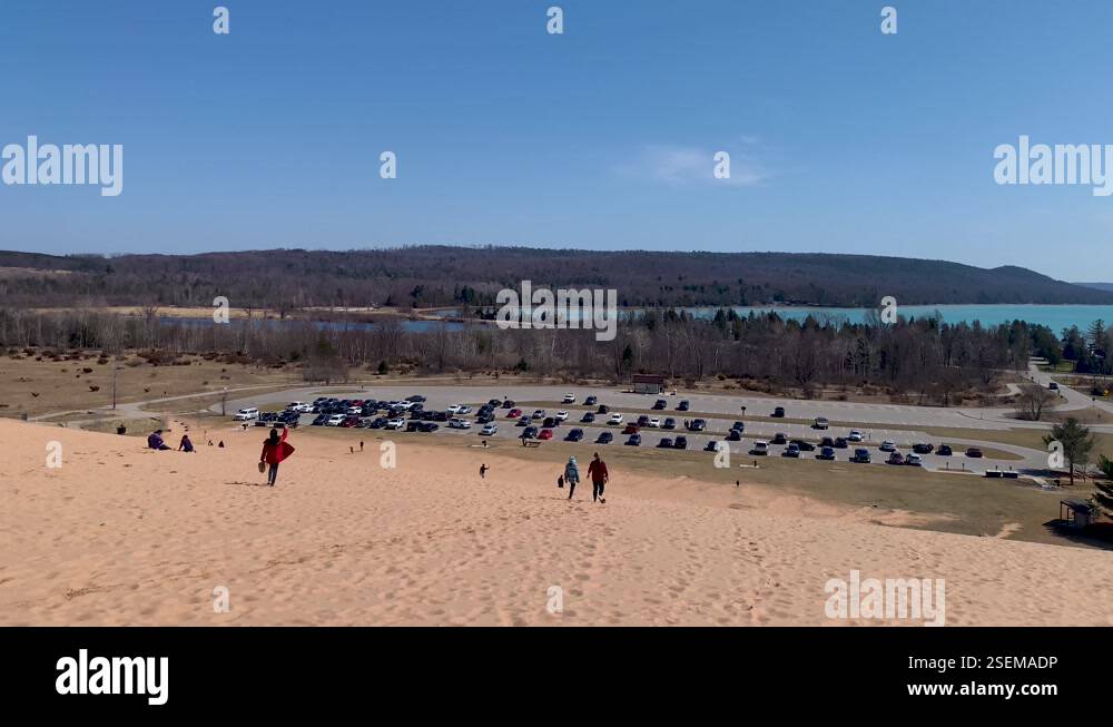 Tourist hiking on the giant sand dunes of sleeping bear dunes national ...