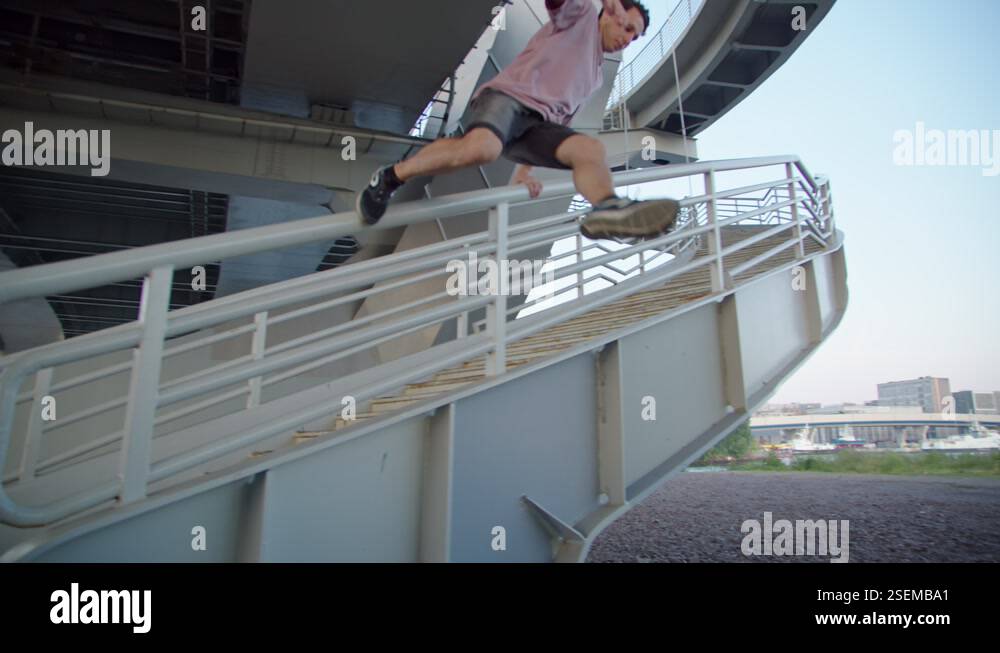 the parkour rider jumping over the railing of the stairs and jumping ...