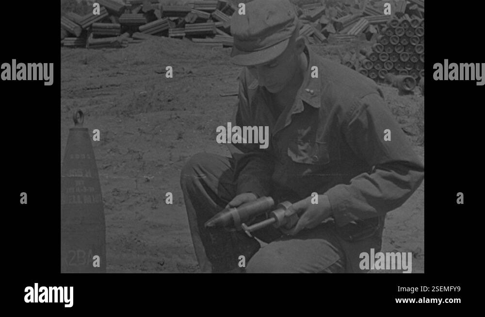 1940s: soldier placing explosive shell inside mortar and then ...