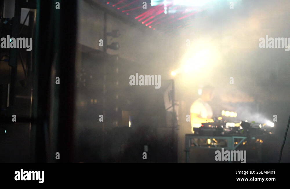 DJ working at music concert with light show, side view boom up Stock ...