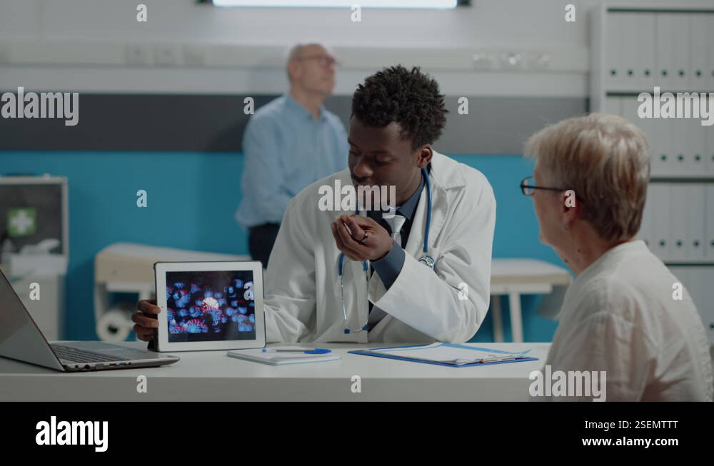 Young doctor analyzing virus animation on tablet with old woman Stock ...