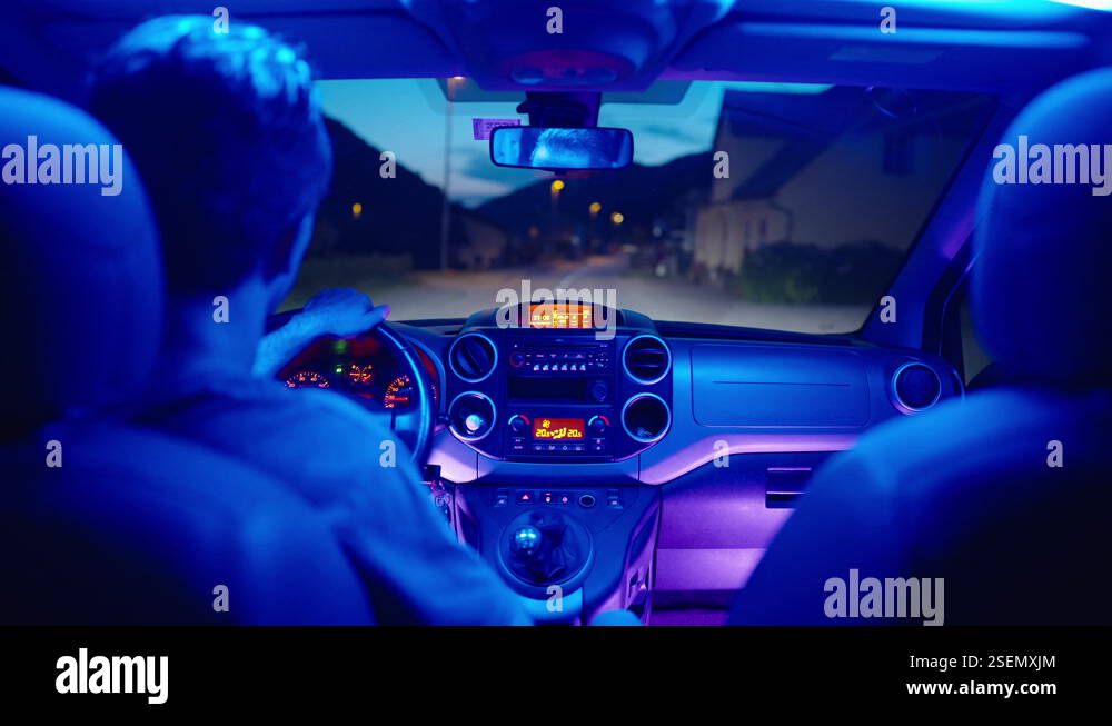 Neon lights glow inside the car while driving in slow motion at night ...